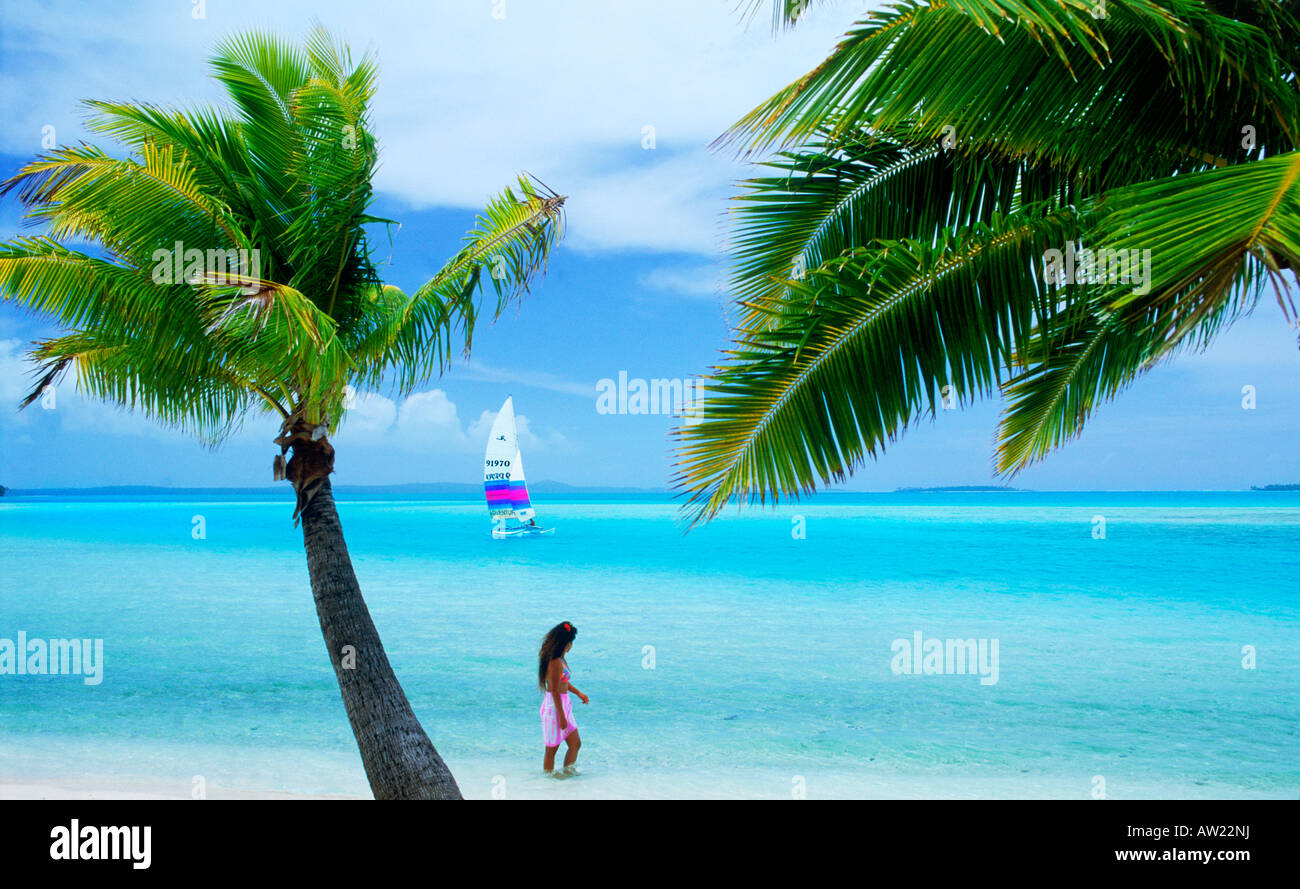 Woman walking sandy One Foot Island shore with catamaran crossing ...