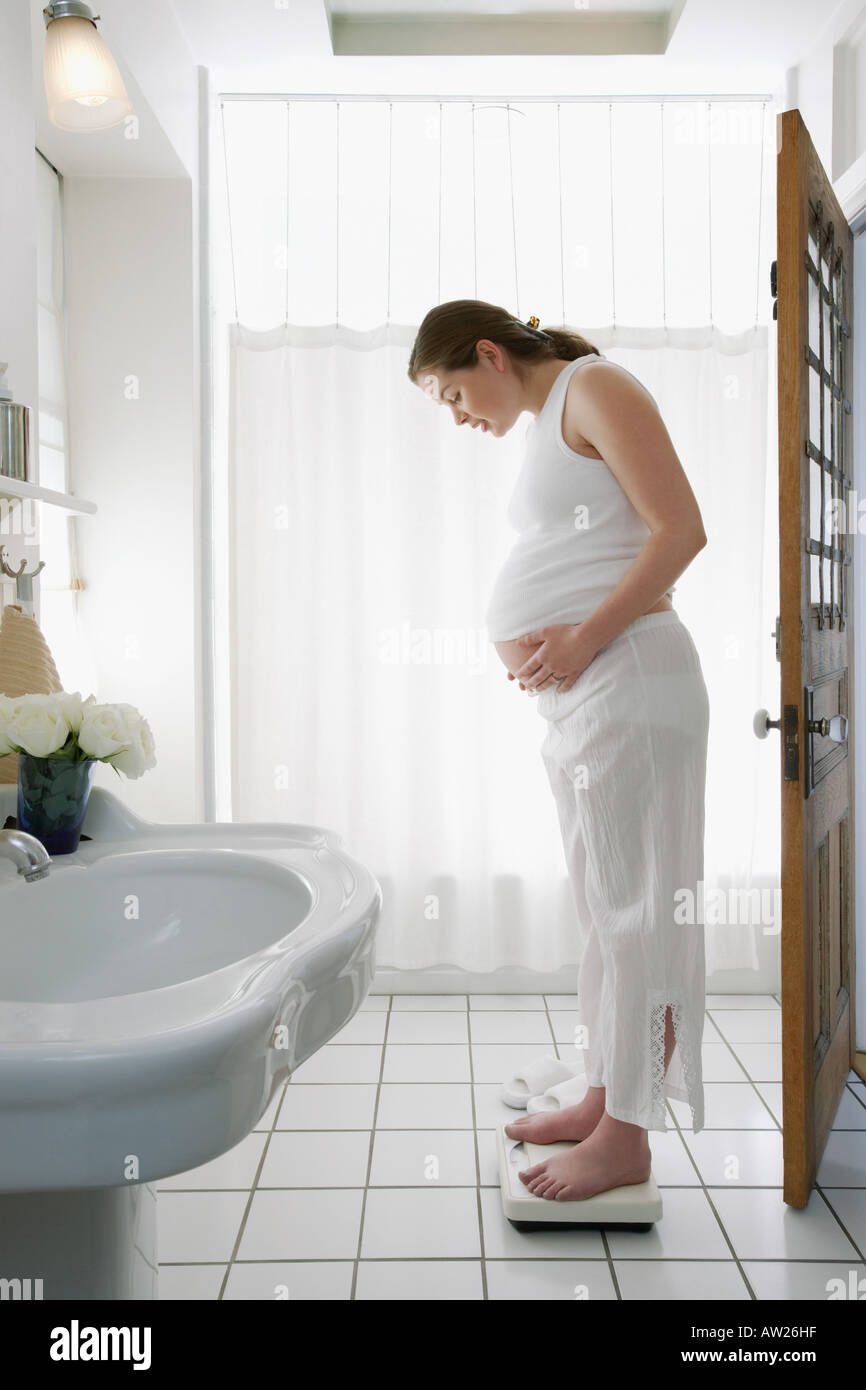 Pregnant woman on weight scales Stock Photo - Alamy