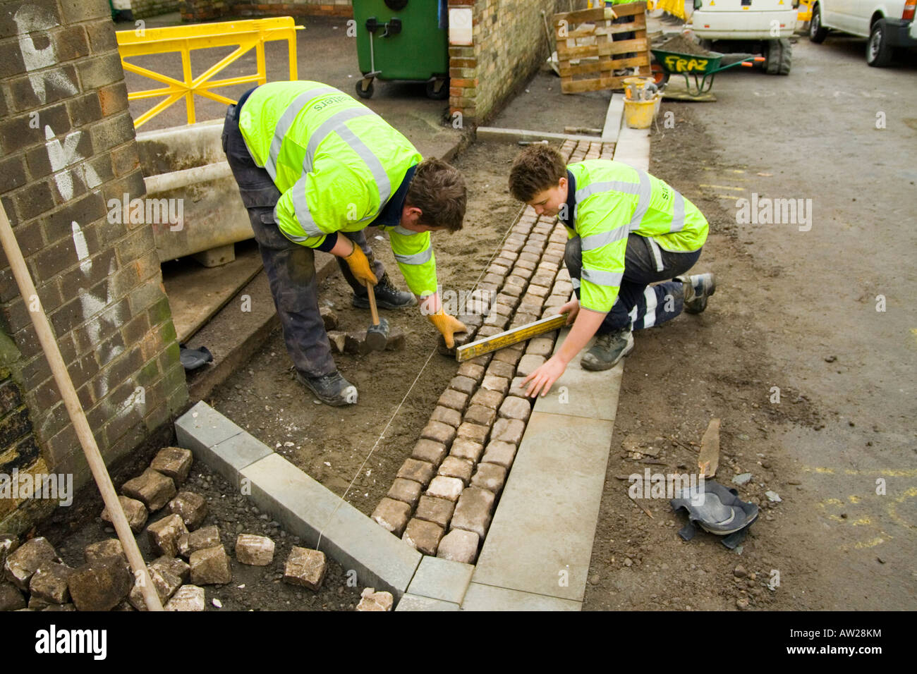 Men at work, laying a vehicle crossing, block paved. Road engineering ...