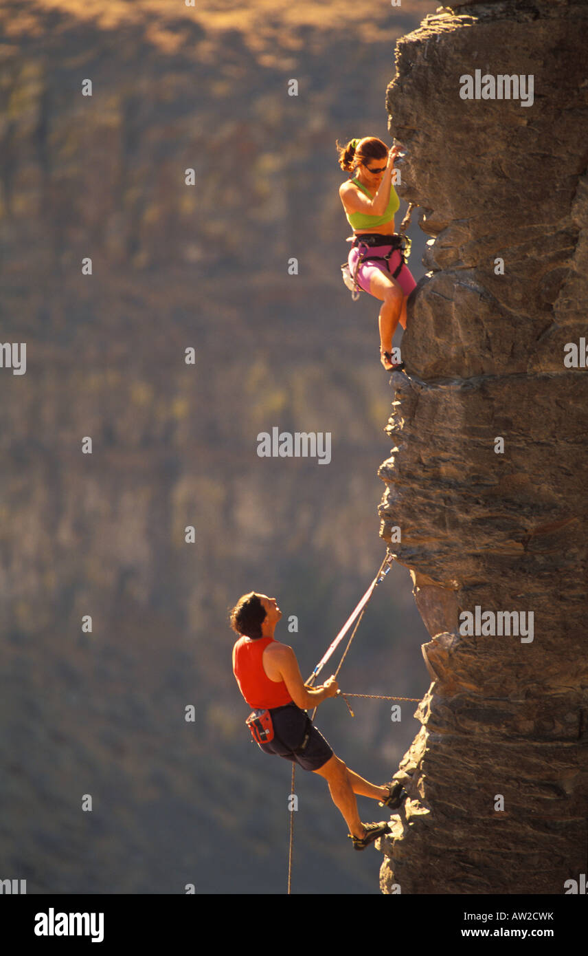 A couple climb a vertical basalt rock face in central Washington State ...