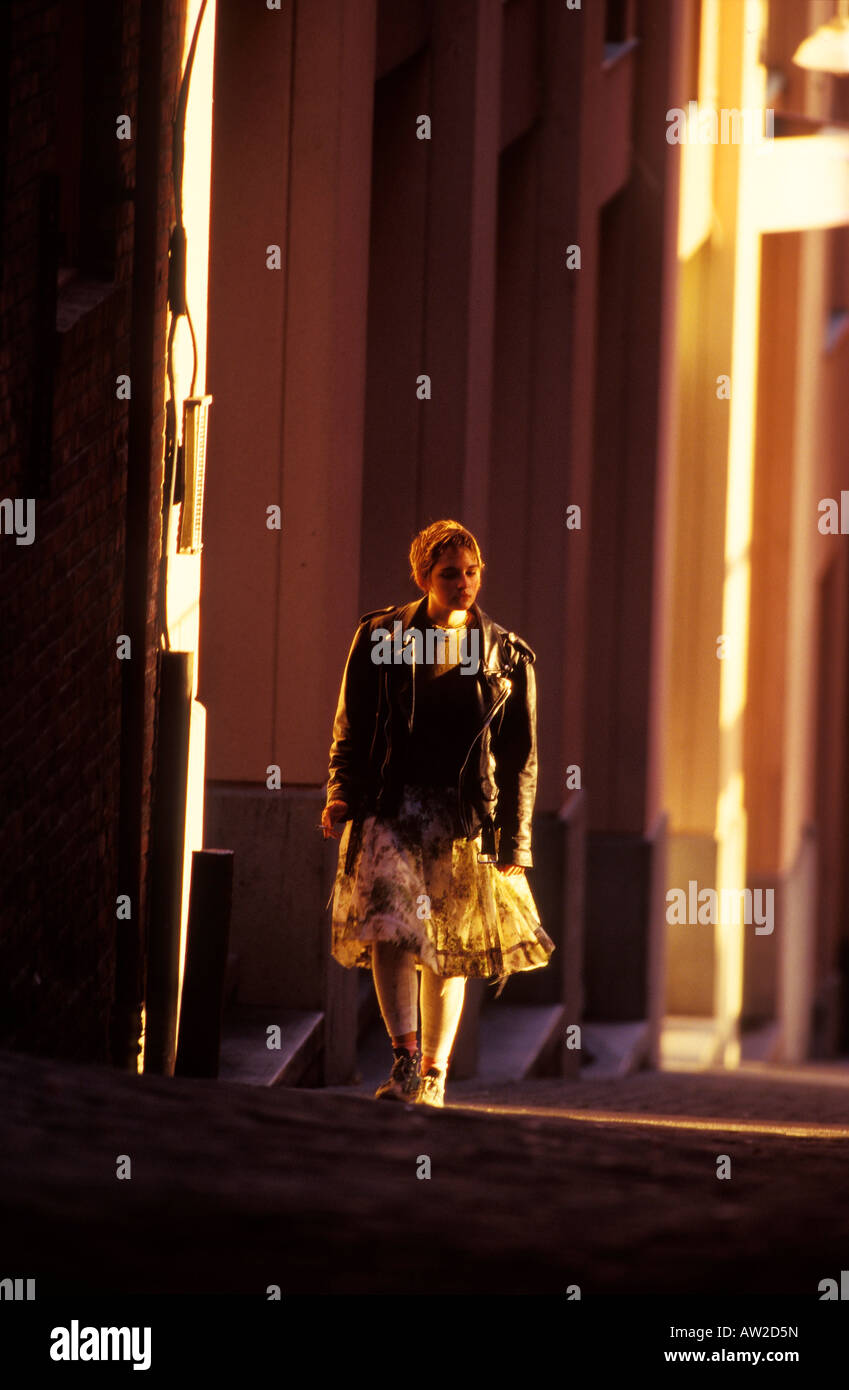 A homeless teenaged girl walks forlornely in an alley in a city Stock ...