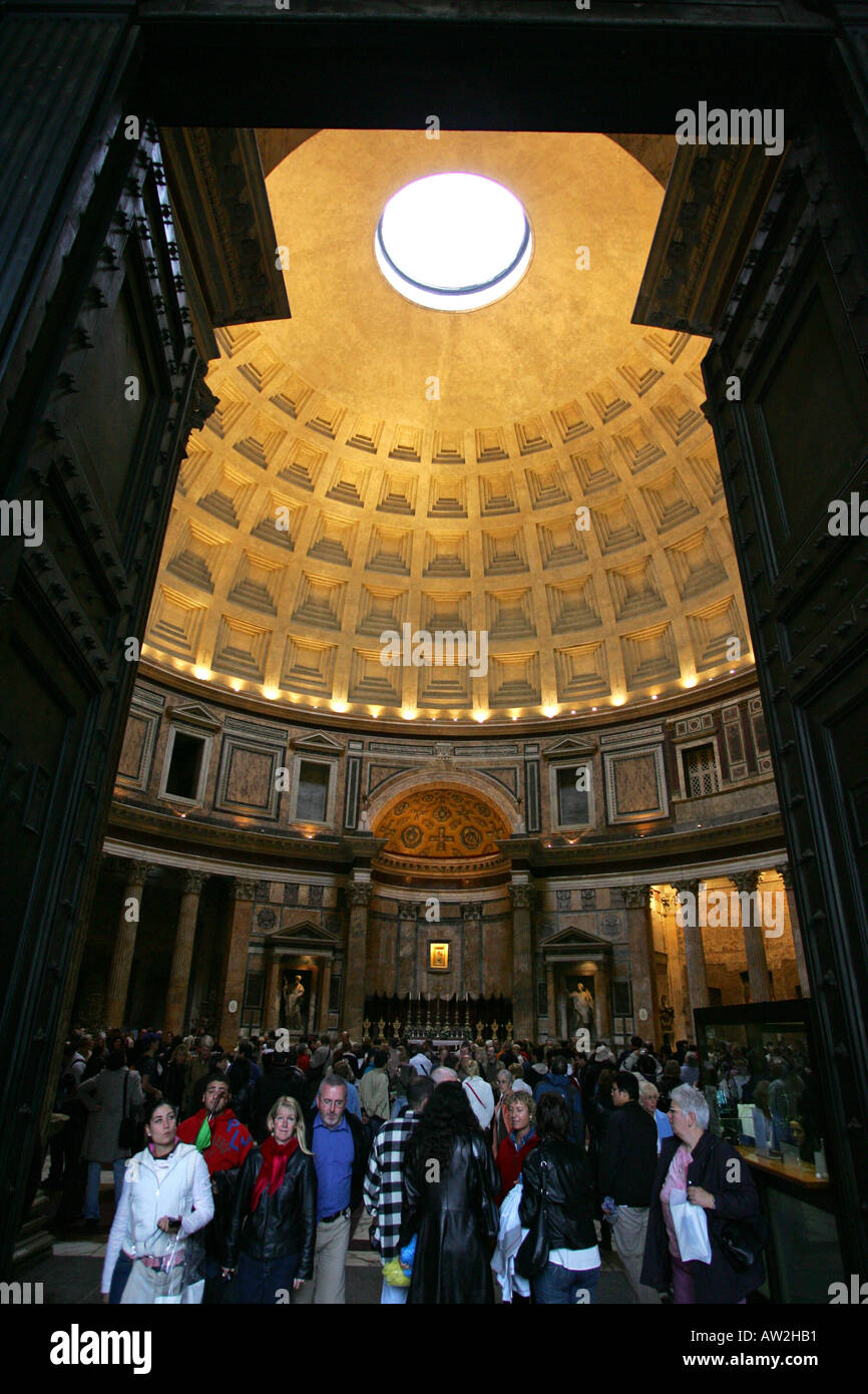 Tourists enter exit through giant wooden doors the Pantheon building ...