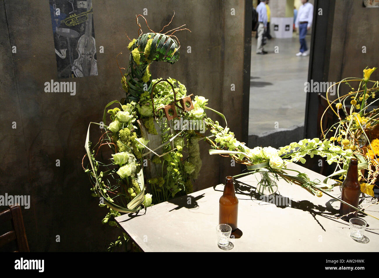 Stylized floral stick man with metal eyes hanging in front on wire ...