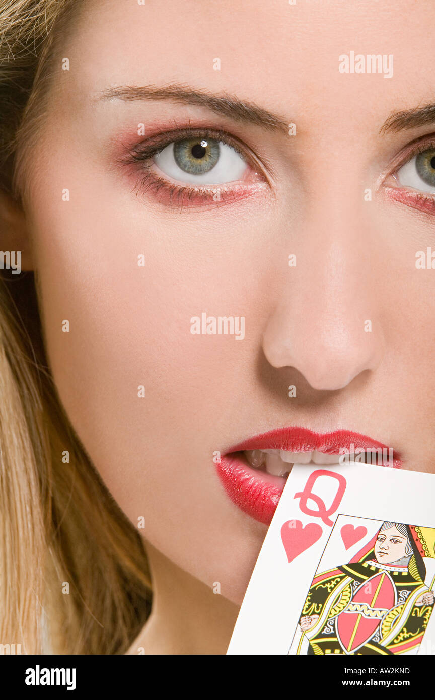 Woman biting a playing card Stock Photo - Alamy