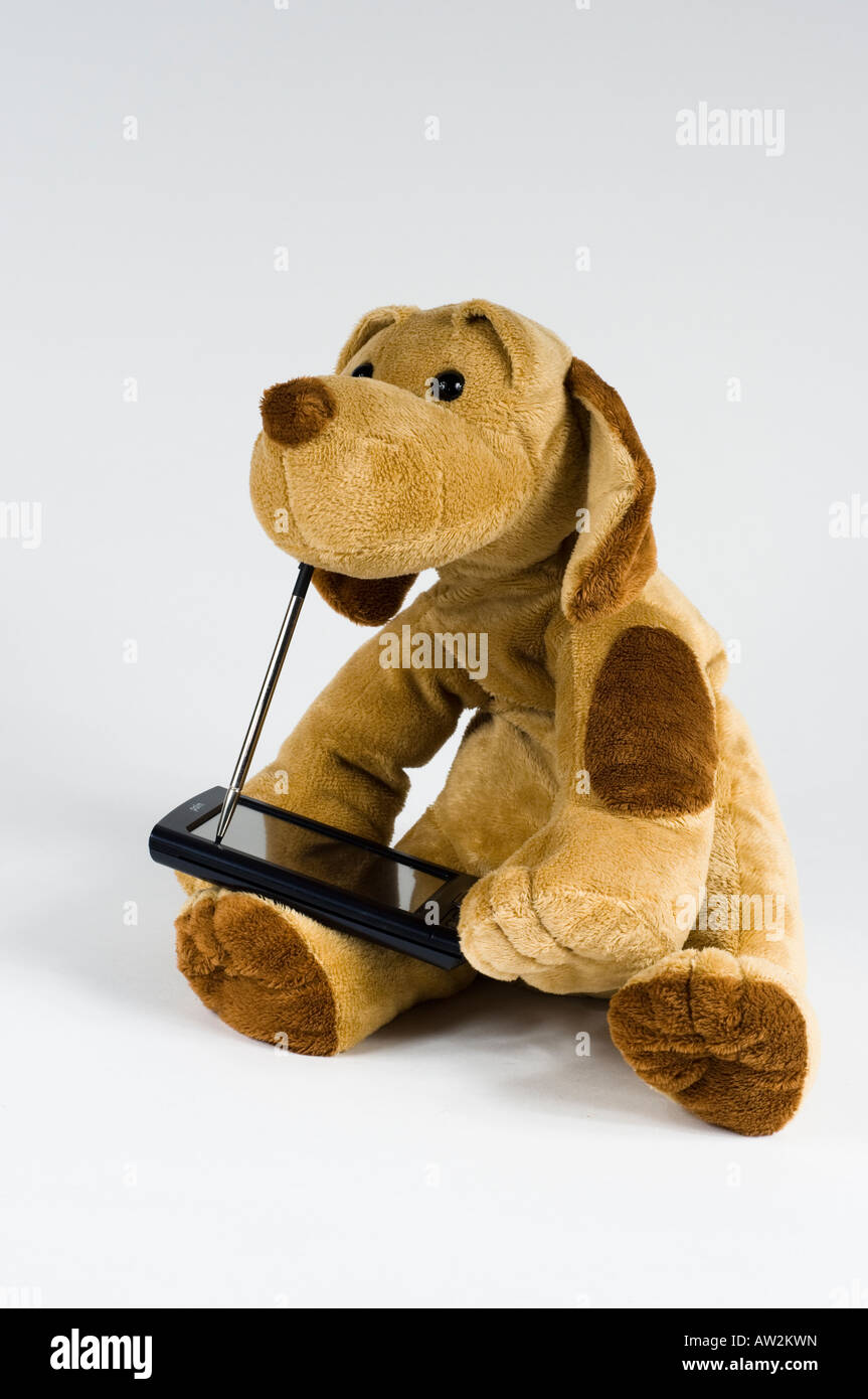 brown soft stuffed toy dog with a pda in his lap with the pencil in his ...
