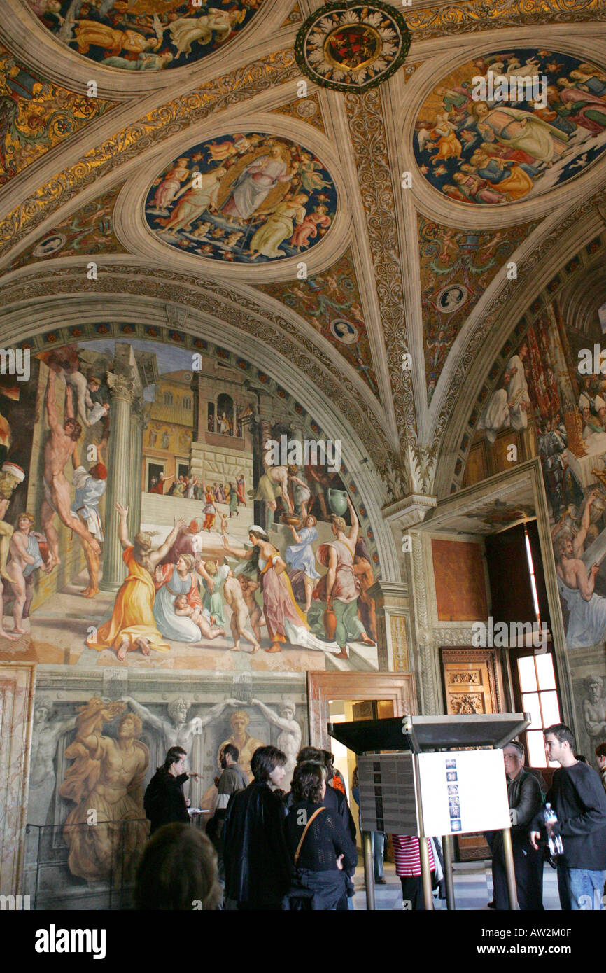 Tourists look upwards at the fine art fresco paintings on walls and ...
