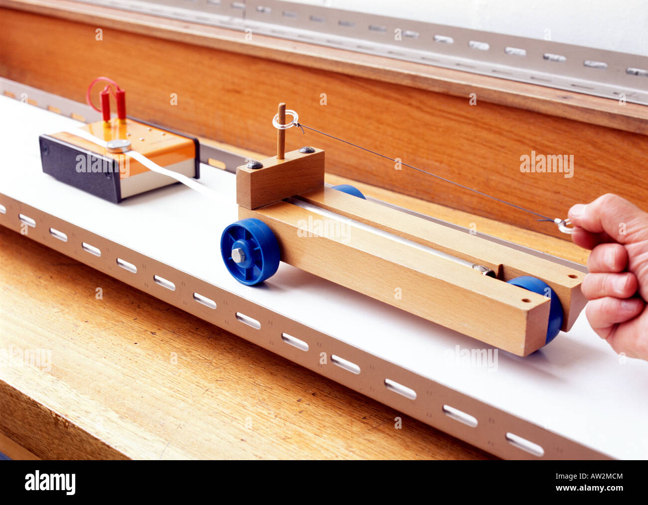Accelerating a dynamics trolley with one elastic Stock Photo - Alamy