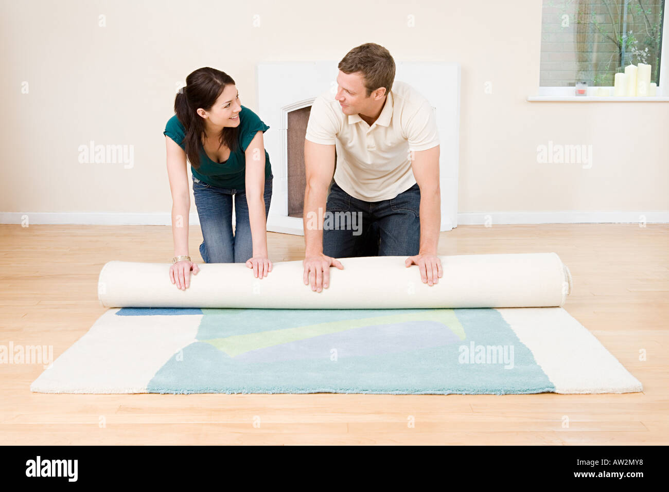 Couple rolling out rug Stock Photo - Alamy