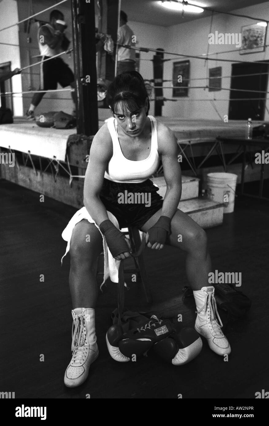 A young woman boxer sits exhausted on a stool in a boxing gymn Stock ...