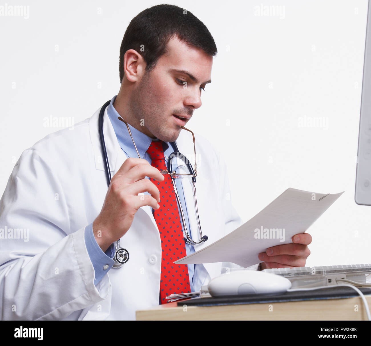 male medical doctor looking at document Stock Photo - Alamy