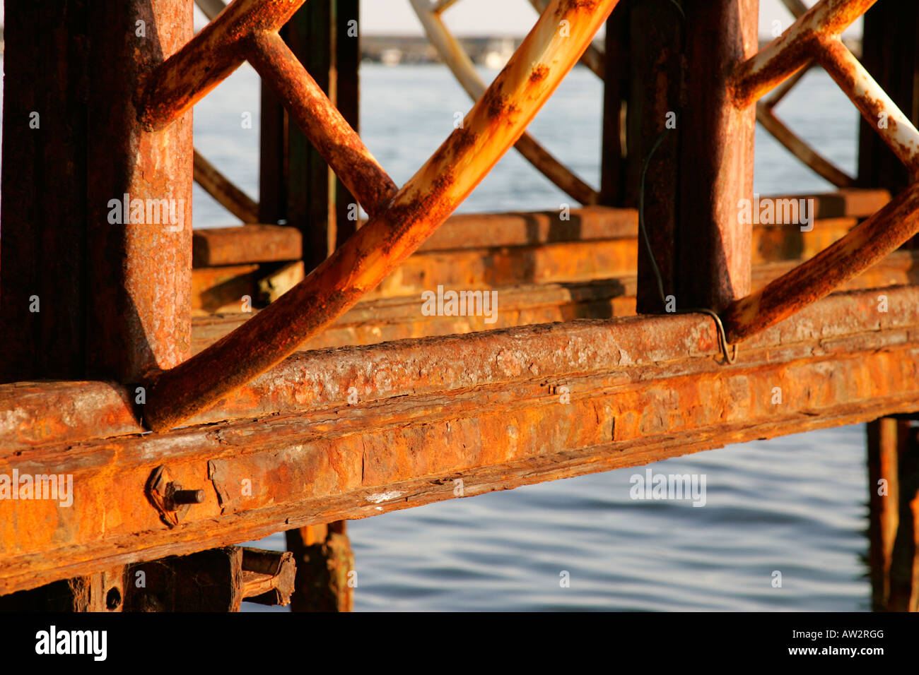 Rusty steel pier support pillars water sea iron work seaside sunset ...