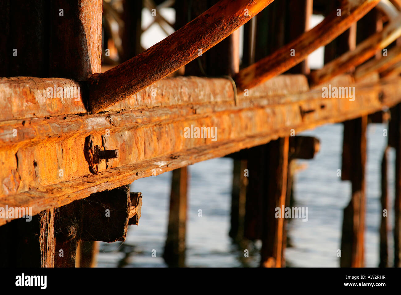 Rusty steel pier support pillars water sea iron work seaside sunset ...