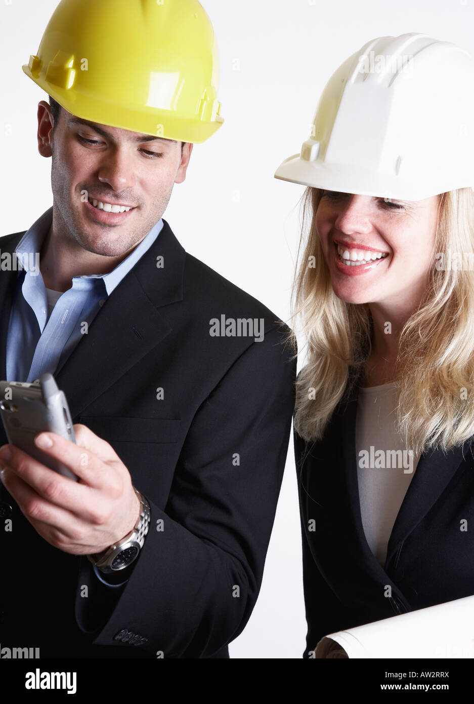 man and woman architects wearing hard hats looking at wireless computer ...