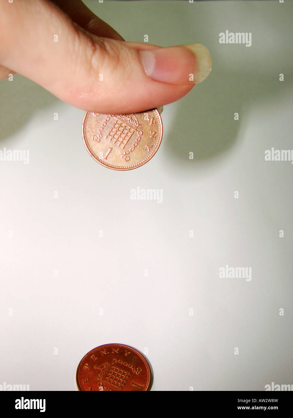 Index finger and thumb holding a penny coin Stock Photo - Alamy