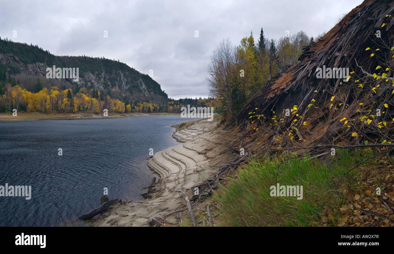 Shore of Montreal River with pile of timber left behind by logging ...