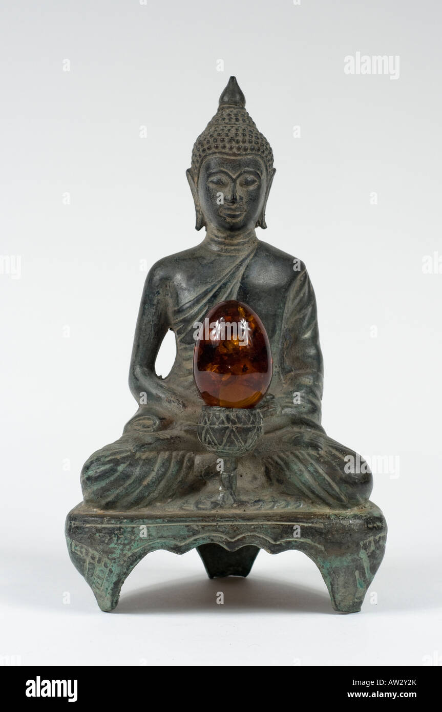 Buddha statue with an amber egg at the center white background Stock ...