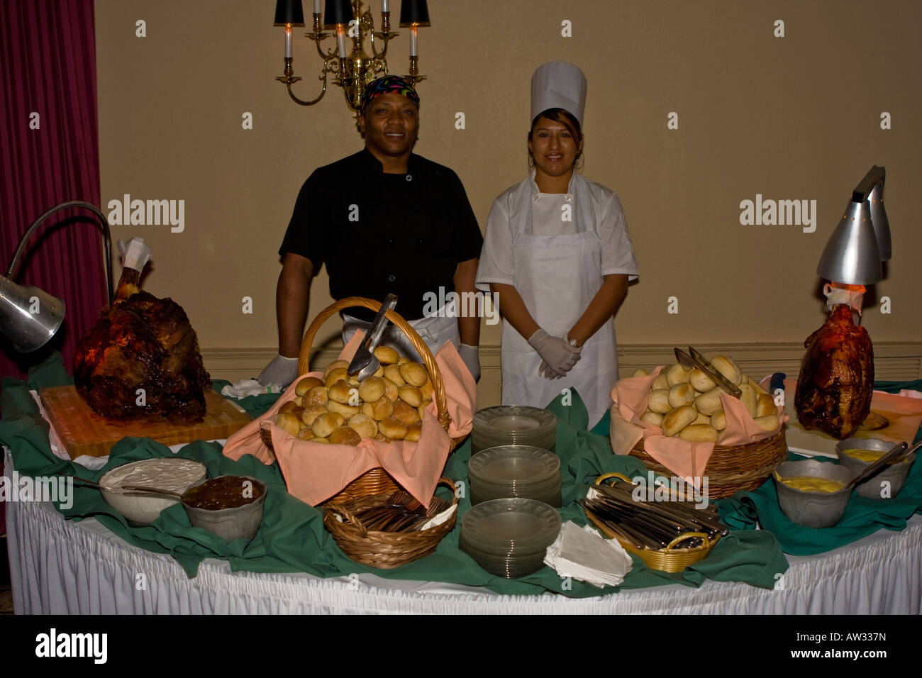 Black Male and Hispanic Female Servers at Buffet Table Stock Photo - Alamy