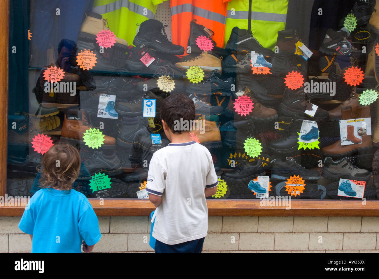 Children looking at boots shoes and trainers on display in the window ...