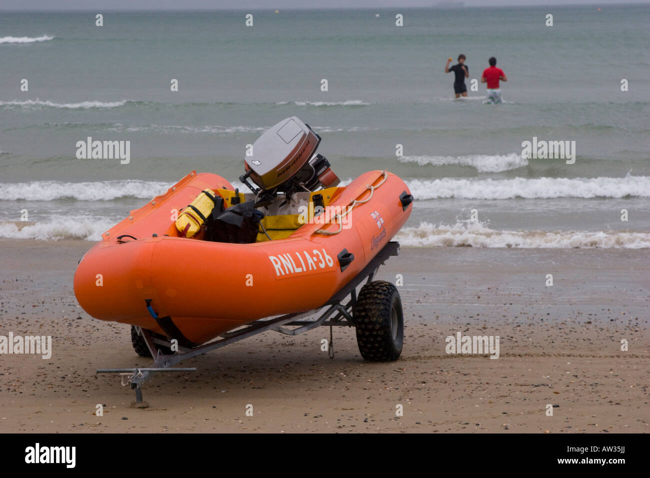 Two swimmers braving the cold sea the inflatable lifeboat is on standby ...