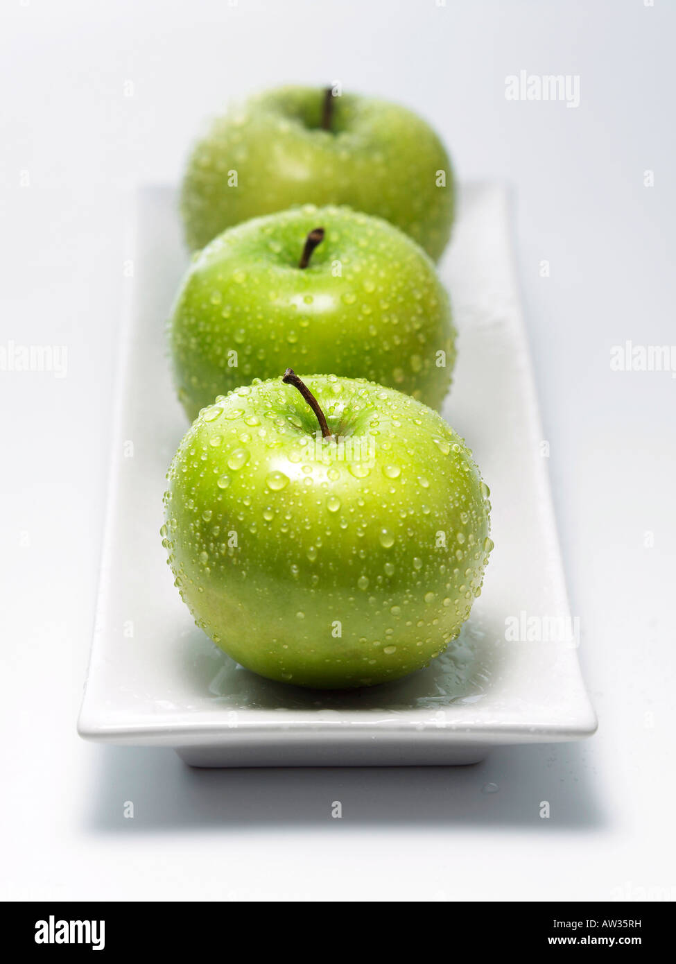 three green apples in a row Stock Photo - Alamy