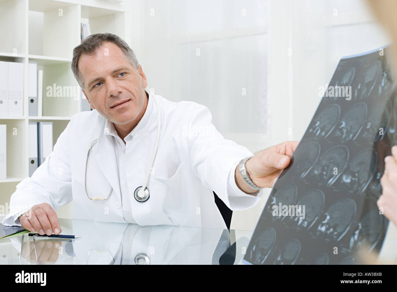 Doctor showing scan to patient Stock Photo - Alamy