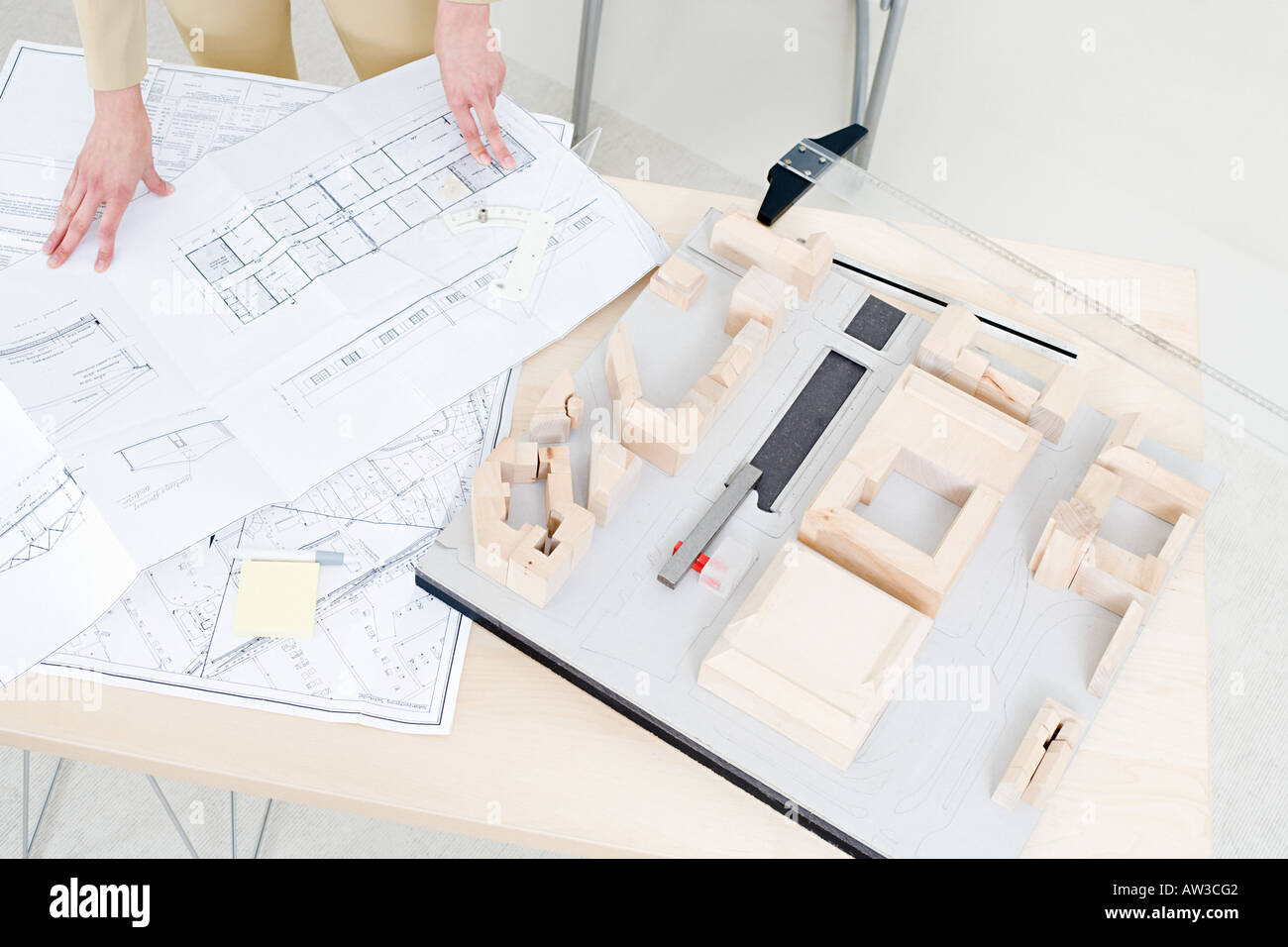 Architect with fashion model and plans Stock Photo - Alamy