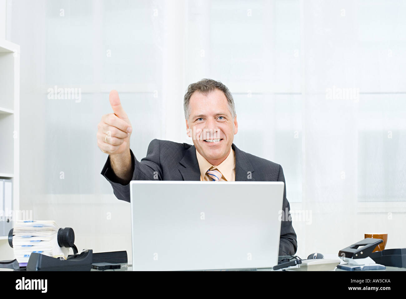 Businessman giving thumbs up Stock Photo - Alamy