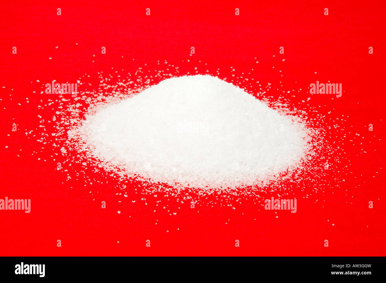 A pile of sugar on a red background Stock Photo - Alamy
