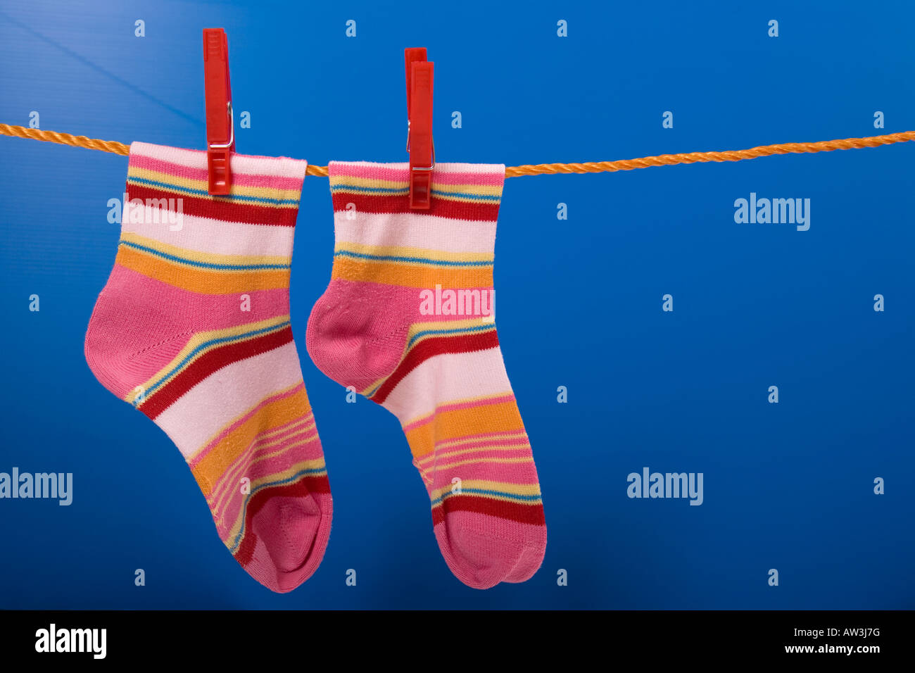 Pair of children's sock hanging on a string Stock Photo - Alamy
