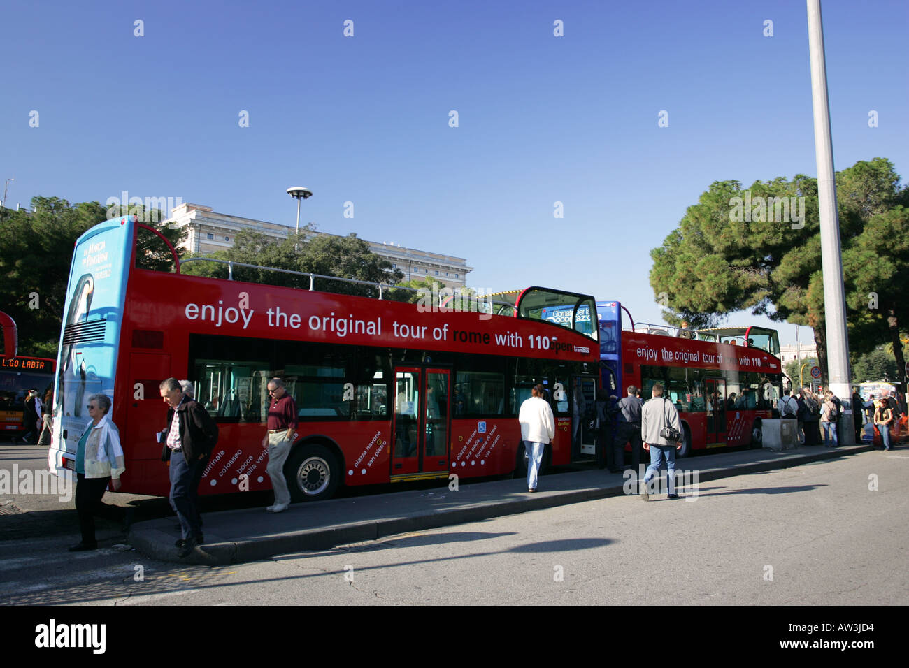 Tourists board the 110 open top red Rome tour bus for an official city tour of major landmarks ...