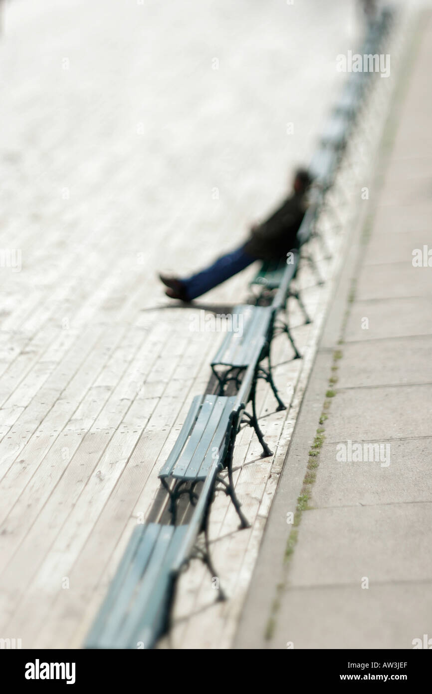 Indistinct person sitting on park bench Stock Photo - Alamy