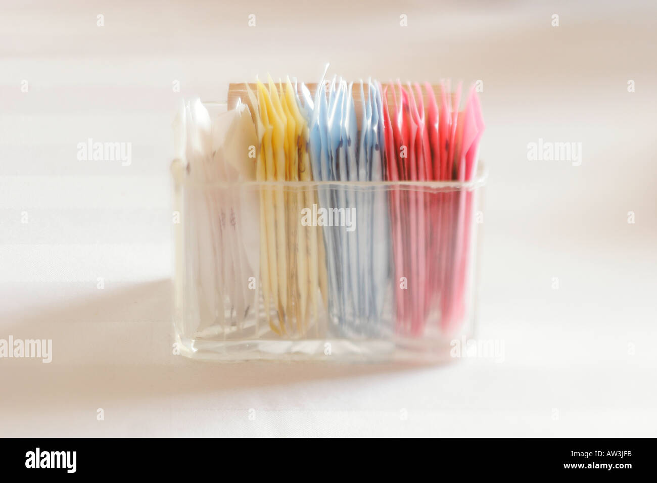 packages of sugar and artificial sweetener in glass container Stock ...