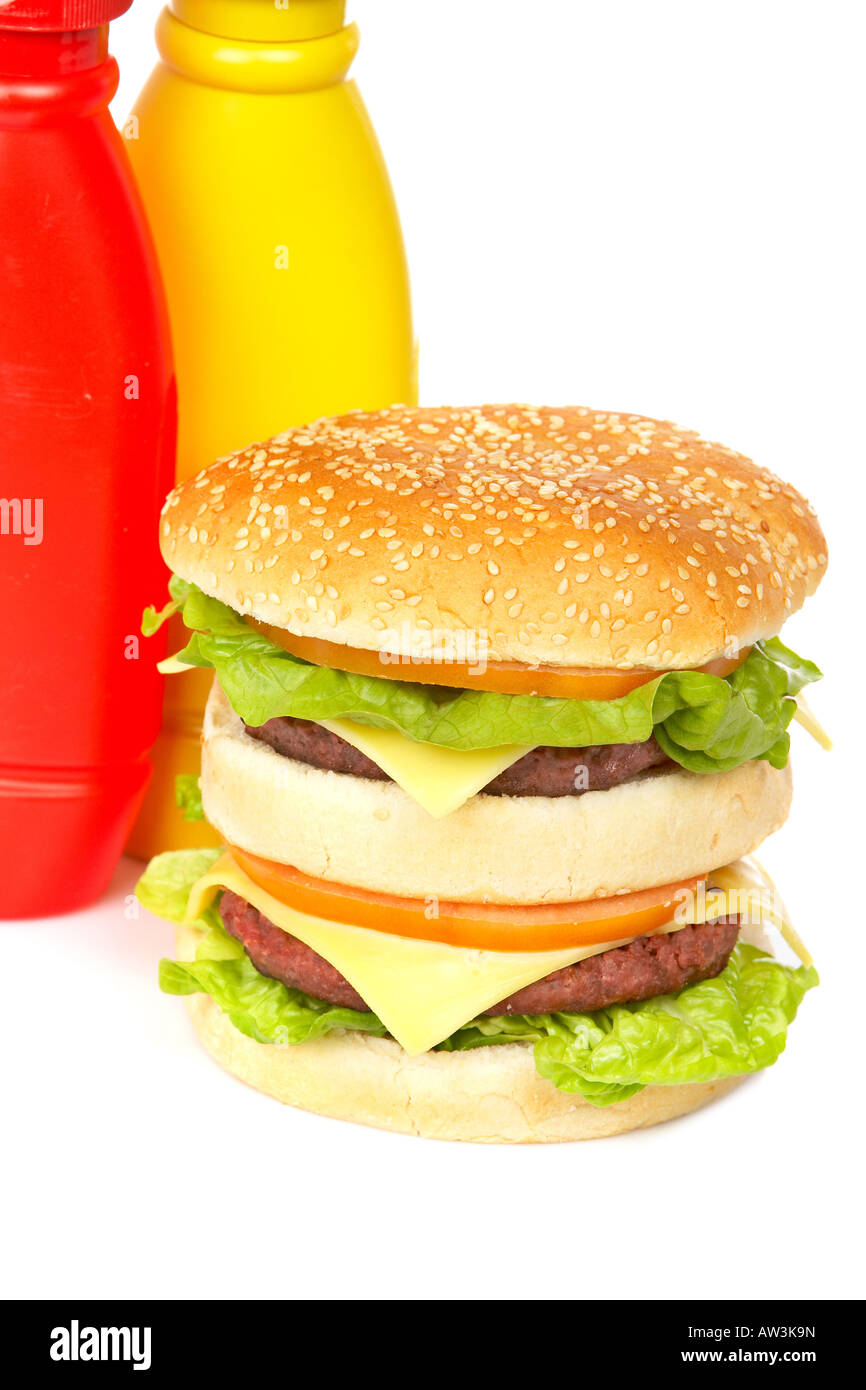 Double cheeseburger with mustard and ketchup bottles reflected on white ...