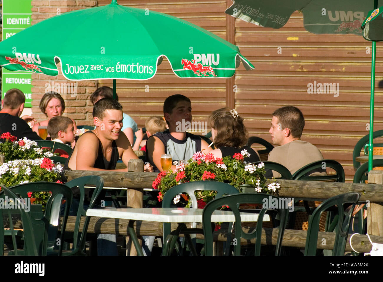 Group of young people enjoying a drink at pavement bar during part of ...