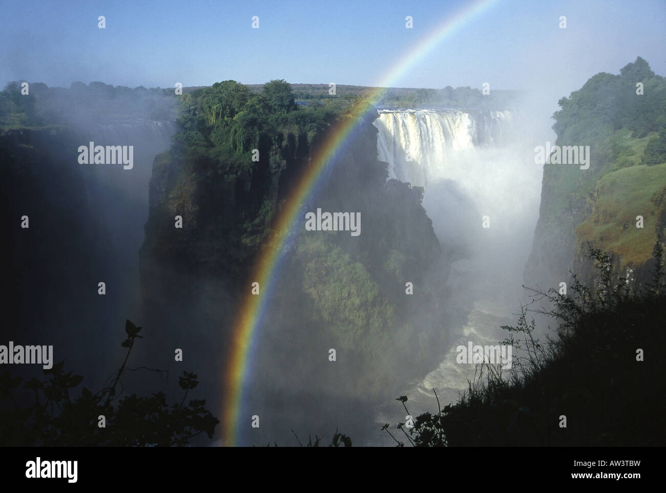 Waterfalls White water cascading over cliff Mist rising Rainbow arc ...