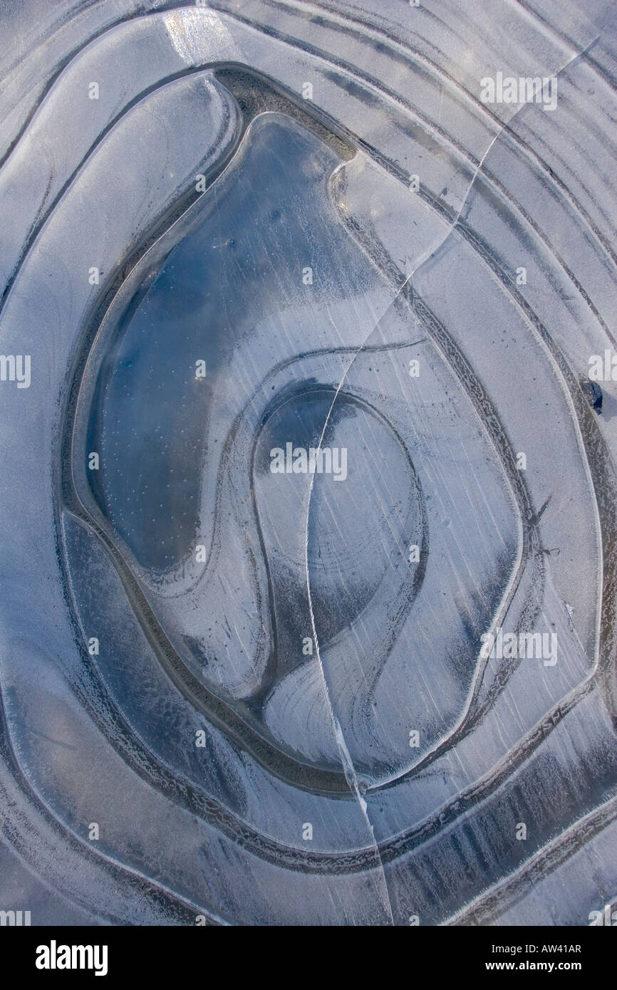 Circular patterns form in ice in a puddle as temperatures rise and fall ...