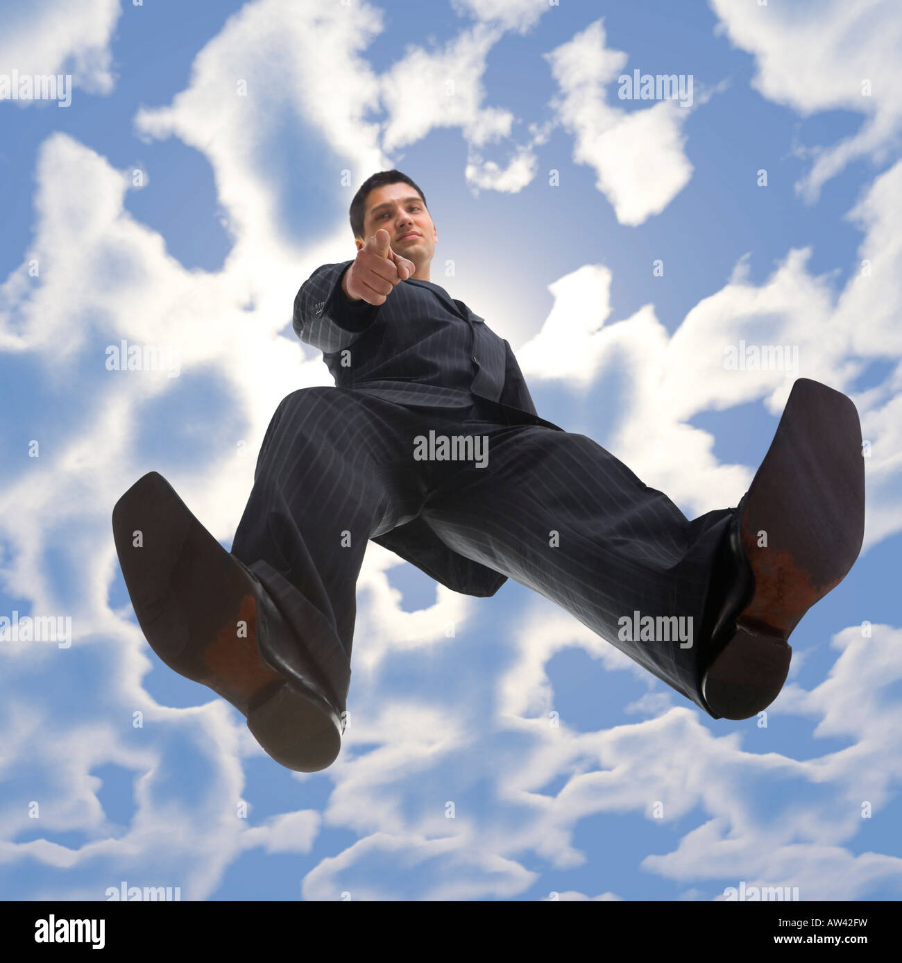 Young serious businessman pointing and looking at camera Low angle view ...