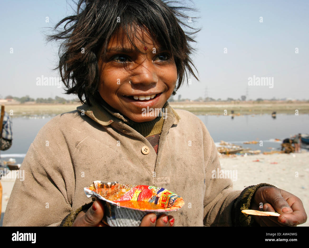 young indian girl eating with spoon along the yamuna delhi india Stock ...