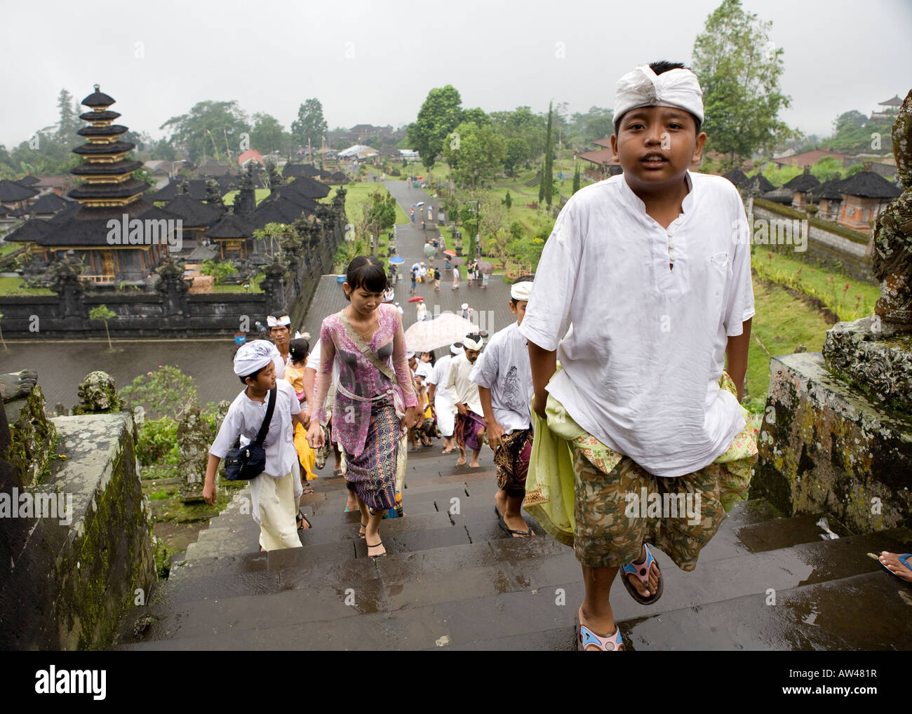 A Balinese Funeral Procession Carrying Umbrellas Climbing The Steps Up ...