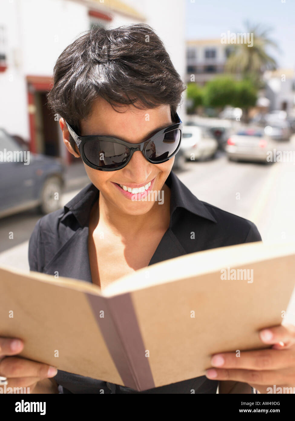 Woman reading and smiling Stock Photo - Alamy