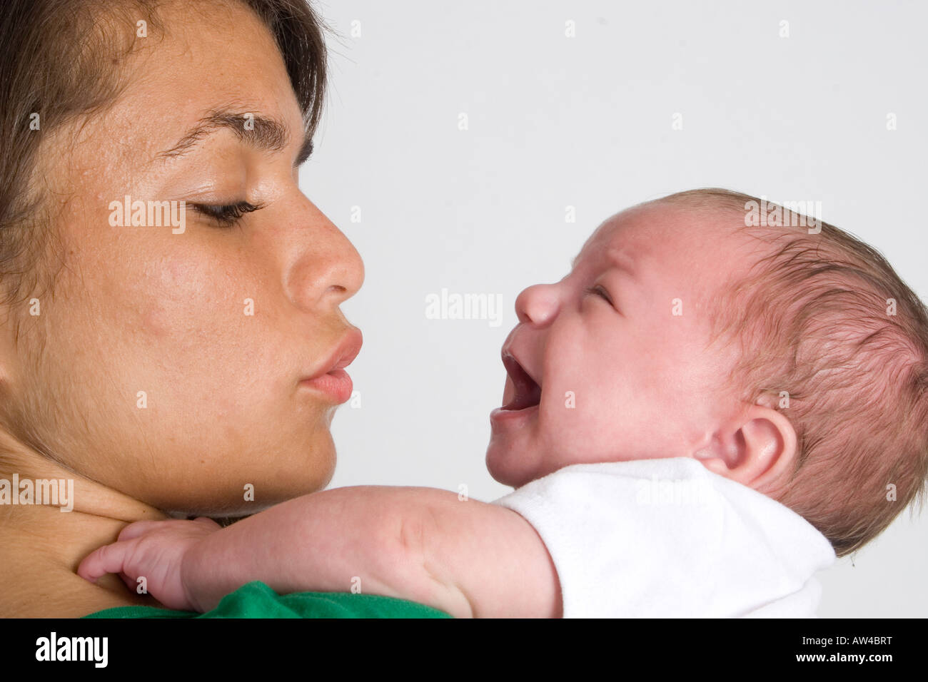 distraught young mother or childminder holding crying baby Stock Photo ...