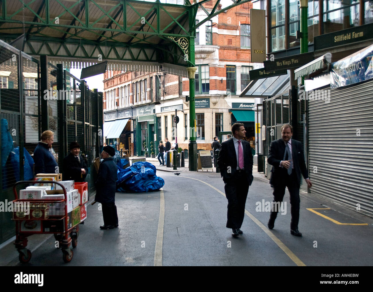 businessmen walking through traditional borough food market, london uk ...