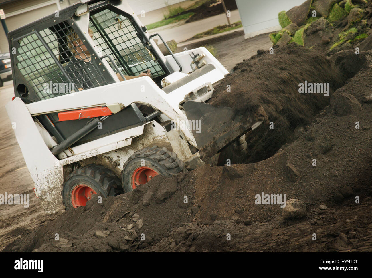 A man operating a skid loader Stock Photo - Alamy