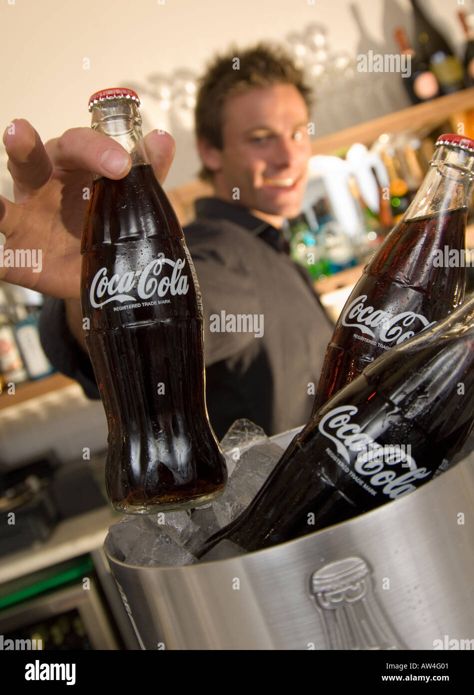 barman picking up an ice cold coca cola from an ice bucket Stock Photo ...