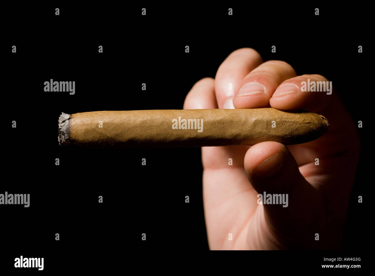 hand holding a cigar in black background Stock Photo - Alamy