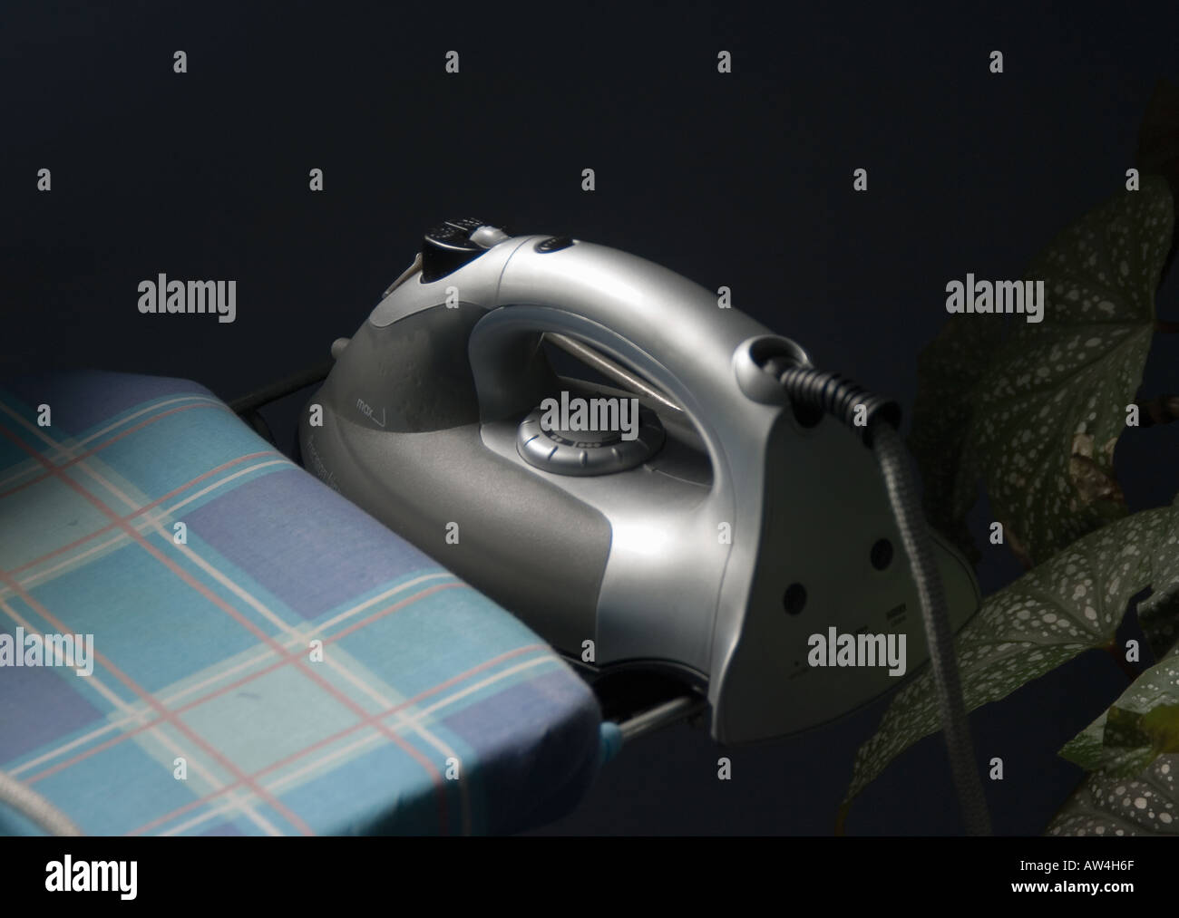 electric steam iron on ironing board Stock Photo - Alamy