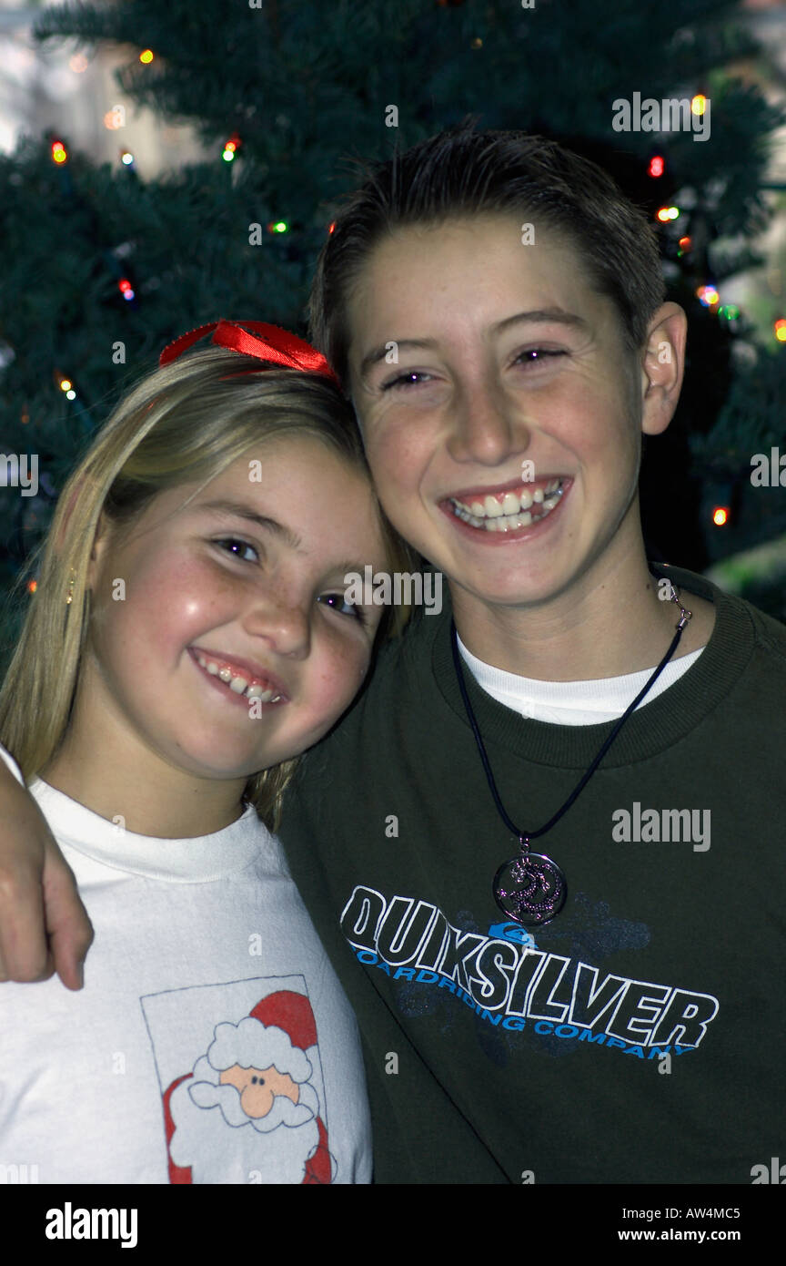 brother and sister by Christmas tree Stock Photo - Alamy
