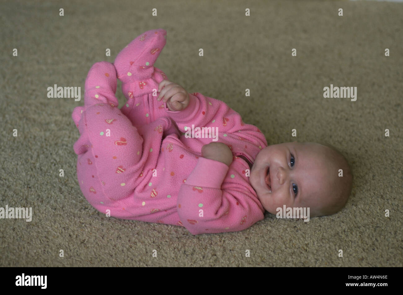 newborn baby smiling on rug Stock Photo - Alamy