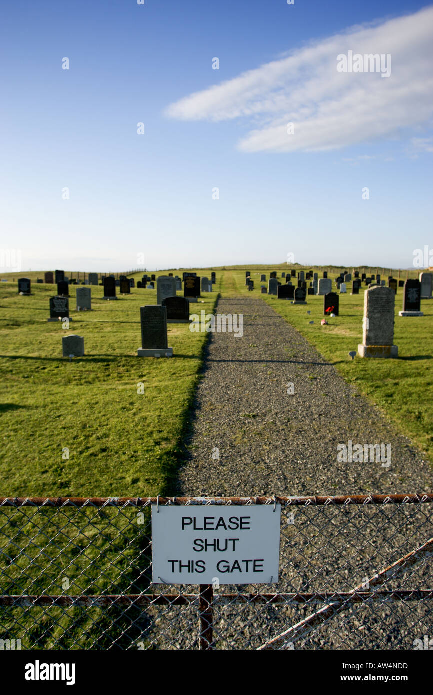 View into a cemetery graveyard with clear blue skies ahead and sign ...
