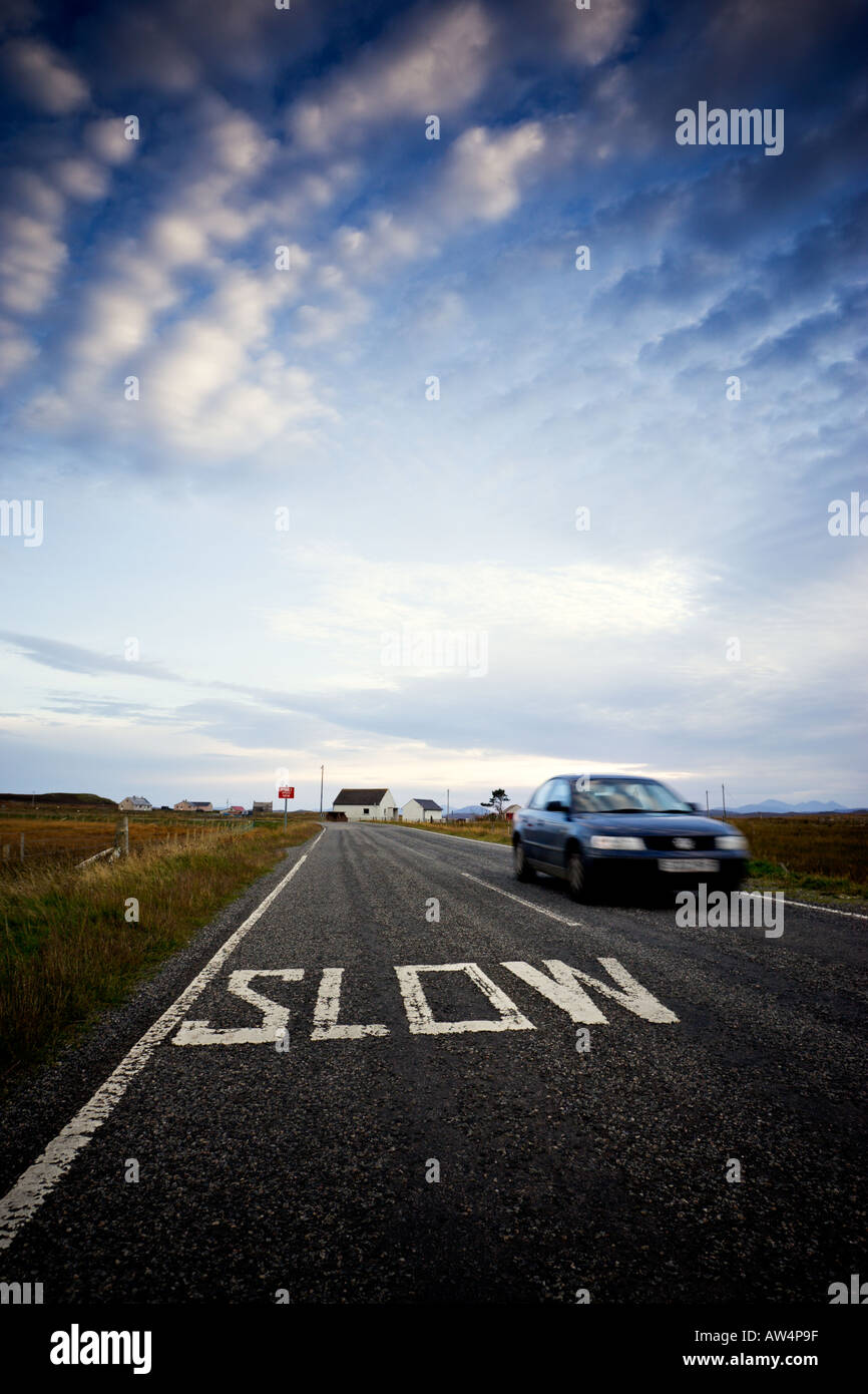 Car driving past slow sign Stock Photo - Alamy